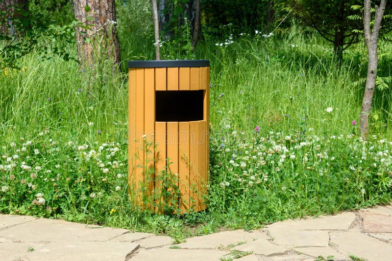 A Wooden Trash Can Sits Next To a Winding Stone Path in a Park. Stock ...