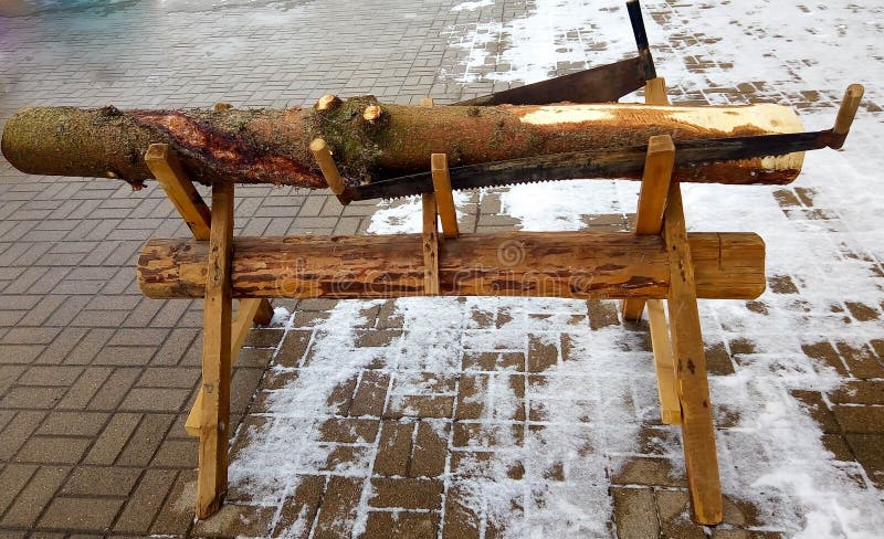 A Wooden Trestle with a Coniferous Log and Two Hand Saws on it Stock ...