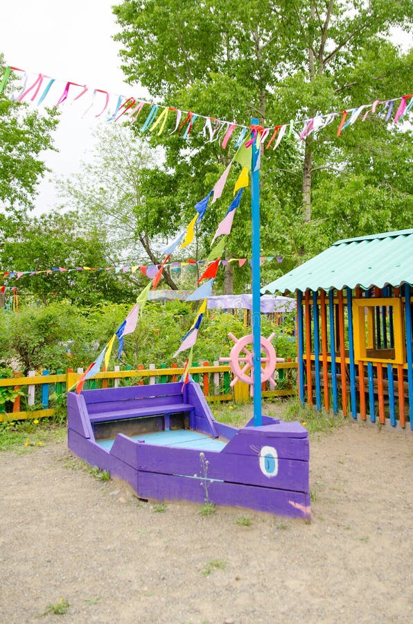 Wooden Violet Boat with Coloful Flags on Sandy Playground Stock Photo ...