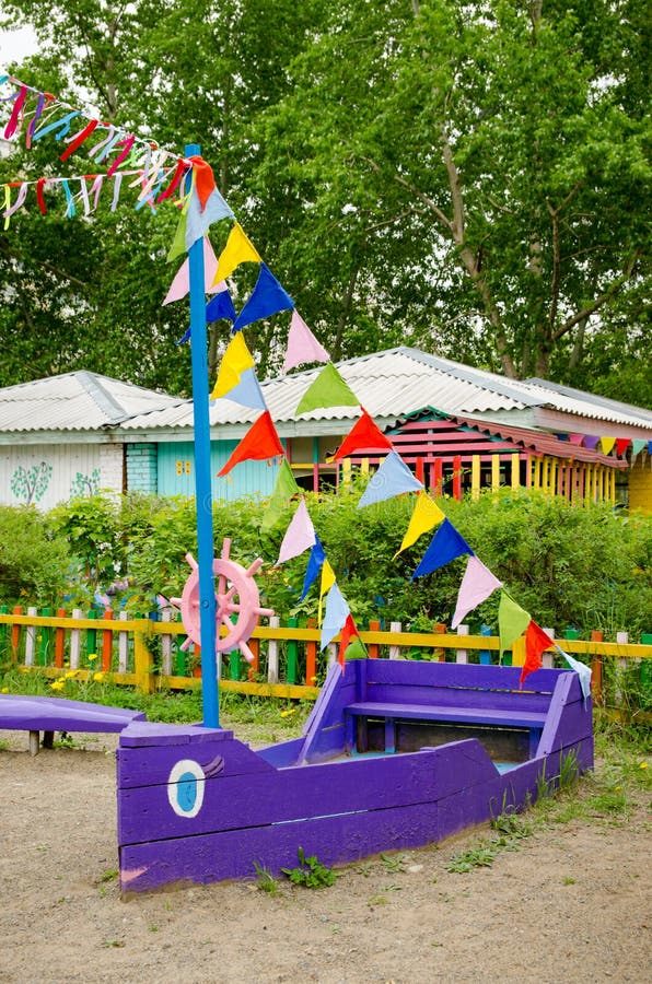 Wooden Violet Boat with Coloful Flags on Sandy Playground Stock Image ...