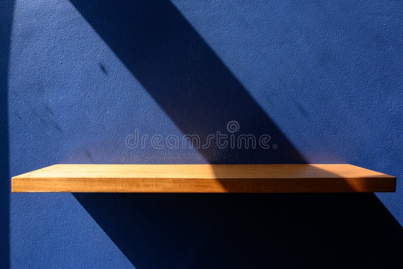 Wooden Wall Shelf on Blue Wall with Shadow and Sunlight on Wall. Empty ...