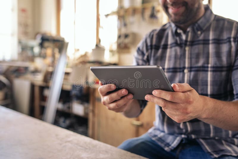 Woodworker Sitting in His Workshop Using a Digital Tablet Stock Image ...