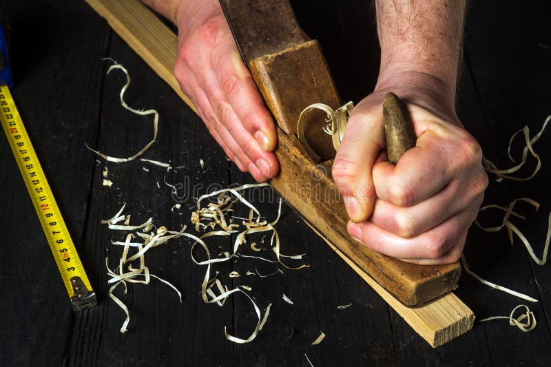 Woodworker Using a Hand Plane To Clean Up a Wooden Board. Hands of the ...