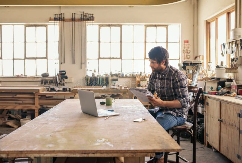 Woodworker Using a Laptop and Reading Notes in His Workshop Stock Photo ...