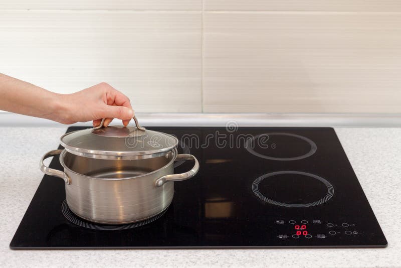 Woomen Hand Open a Saucepan in Modern Kitchen with Induction Stove ...