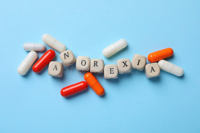 Word Anorexia of Wooden Cubes and Pills on Light Blue Background, Flat ... Word Anorexia of Wooden Cubes and Pills on Light Blue Background, Flat ...