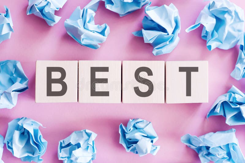 The Word BEST on Wooden Cubes, on a Pink Background with Crumpled ...