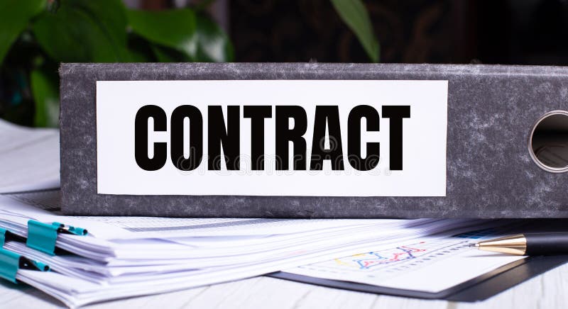 The Word CONTRACT is Written on a Gray File Folder Next To Documents ...