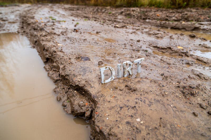 The Word Dirt Composed of Silver Metal Letters on Wet Clay Surface ...