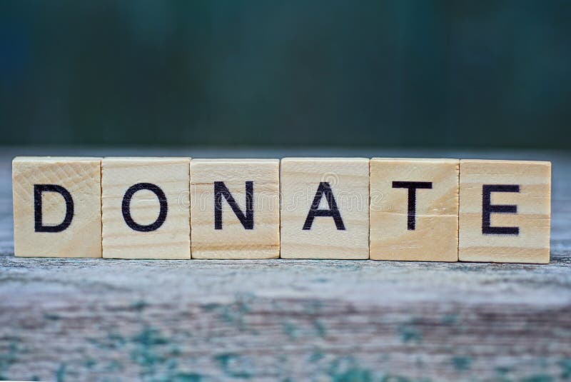 Word Donate from Cut Letters on White Background. Donation Concept. a ...