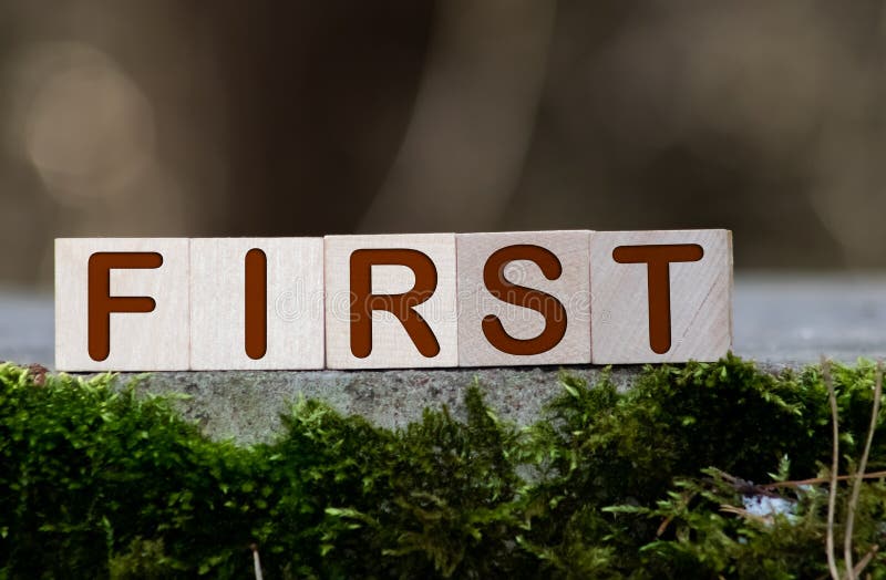 Word FIRST is Written on Wooden Blocks on a Light Background Stock ...