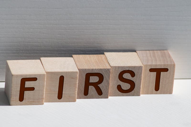Ð¢Word FIRST is Written on Wooden Blocks on a Light Background Stock ...