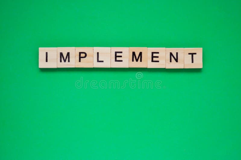 Word Implement. Top View of Wooden Blocks with Letters on Green Surface ... Word Implement. Top View of Wooden Blocks with Letters on Green Surface ...