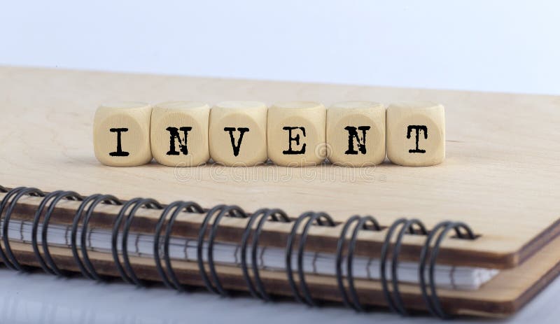 Word INVENT Made with Letters on Wooden Blocks on Wooden Notepad Stock ...