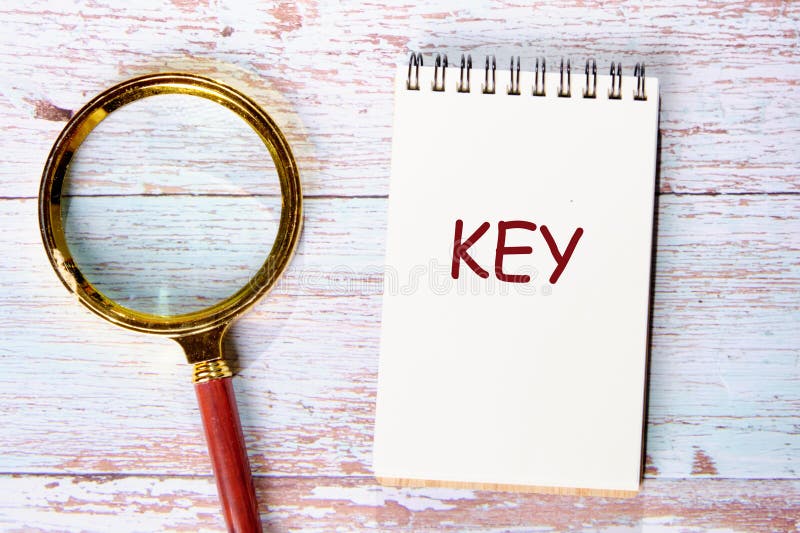 The Word Key in a Notebook Next To a Magnifying Glass on Old Boards ...