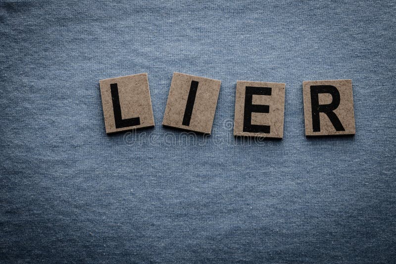 The Word Liar Formed with Wooden Blocks on a Blue Fabric Stock Image ...