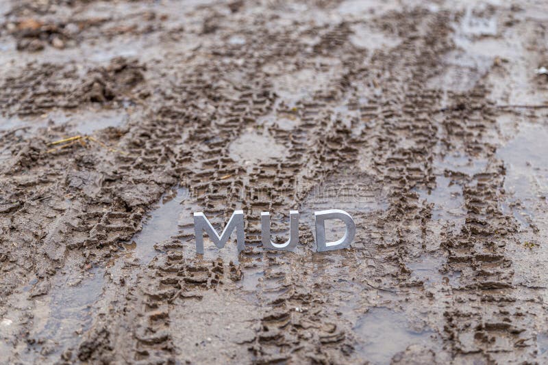 The Word Mud Composed of Silver Metal Letters on Wet Dirt Surface Stock ...