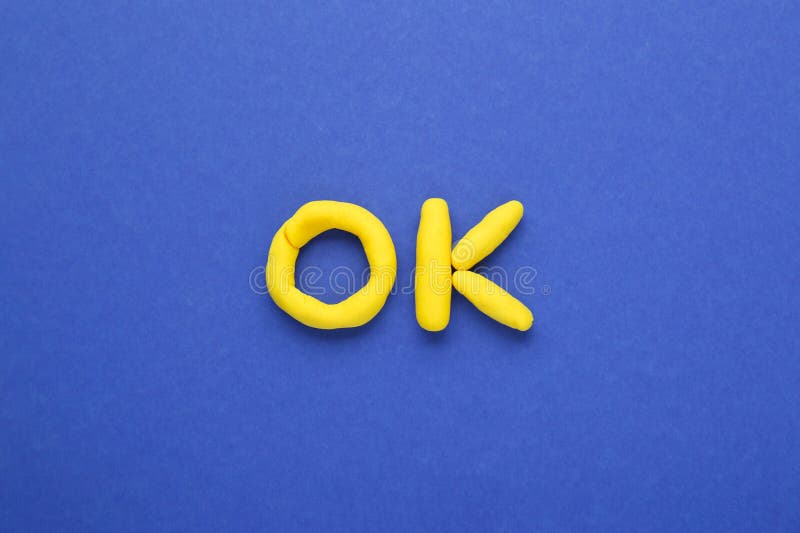 Word Ok Made of Yellow Plasticine on Blue Background, Top View Stock ...