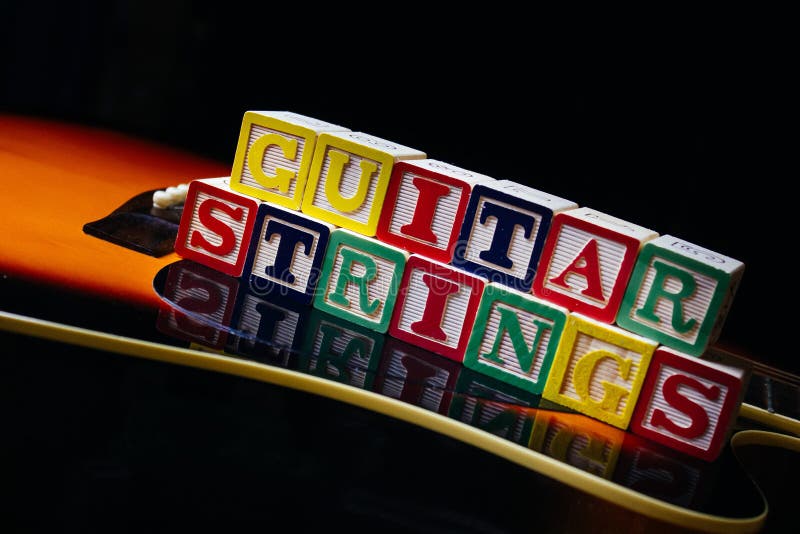 Word or Phrase Guitar Strings Made with Letter Cubes, Standing on ...