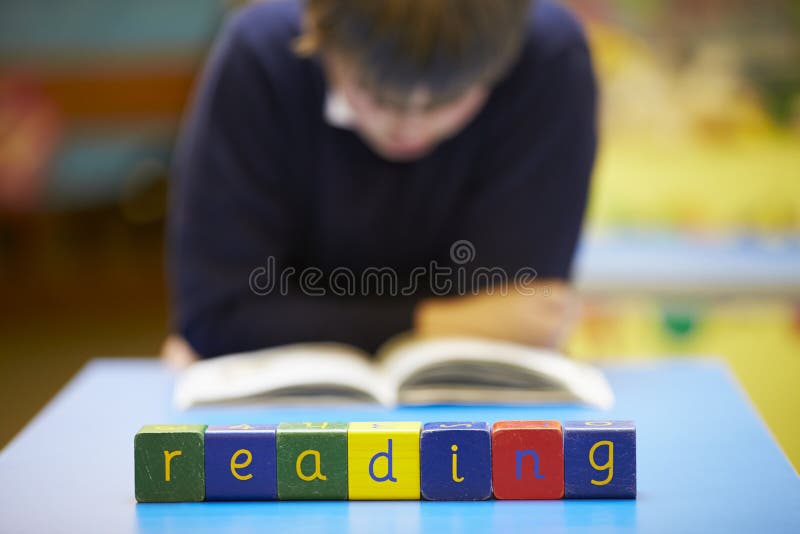 Word Reading Spelt in Wooden Blocks with Pupil Behind Stock Image ...