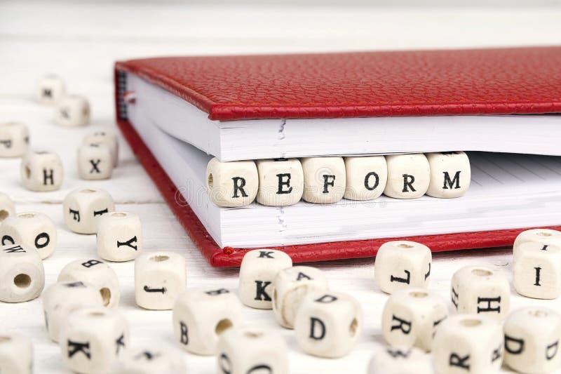 Word Reform Written in Wooden Blocks in Red Notebook on White Wooden ...