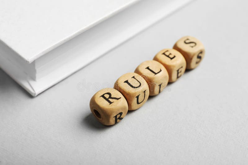 Word Rules Made of Wooden Cubes with Letters and Book on White Table ...