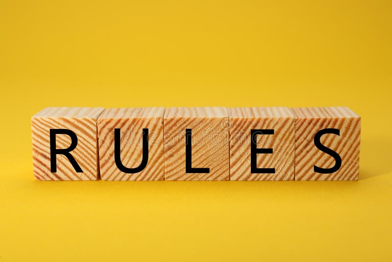 Word Rules Made of Wooden Cubes with Letters on Yellow Background Stock ...
