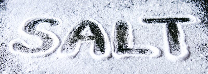 The Word Salt is Written on Small Crystals of Salt Scattered on a Black ...