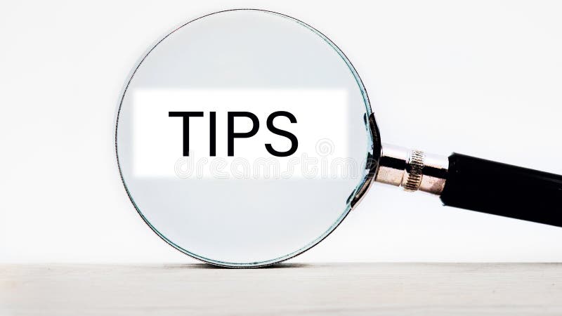 A Word TIPS through a Magnifying Glass on a White Stripe on a Light ...
