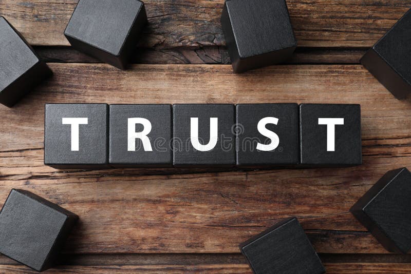 Word TRUST Made with Black Cubes on Wooden Table, Flat Lay Stock Photo ...