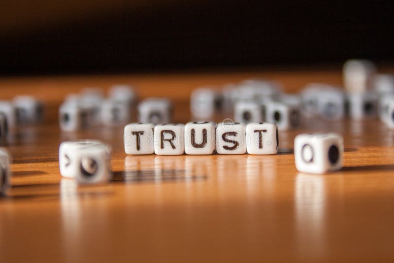 The Word TRUST Made of White Plastic Blocks on the Table. Stock Photo ...