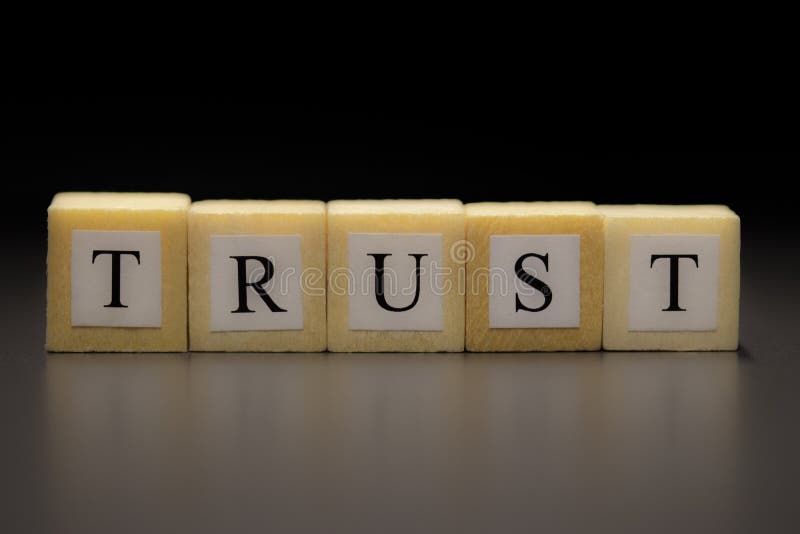 The Word TRUST Written on Wooden Cubes Isolated on a Black Background ...
