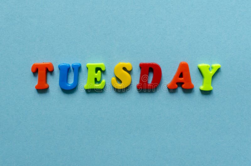 Word `tuesday` of Colored Plastic Magnetic Letters on Blue Paper ...