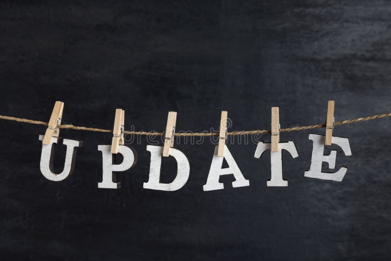 Word UPDATE Held on Clothespin on Rope Against Black Background Stock ...