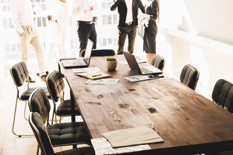 Work Area on the Table in the Foreground. a Team of Young Businessmen ...