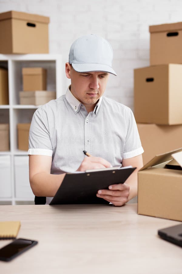 Work and Business Concept - Postman Writes Something on the Clipboard ...