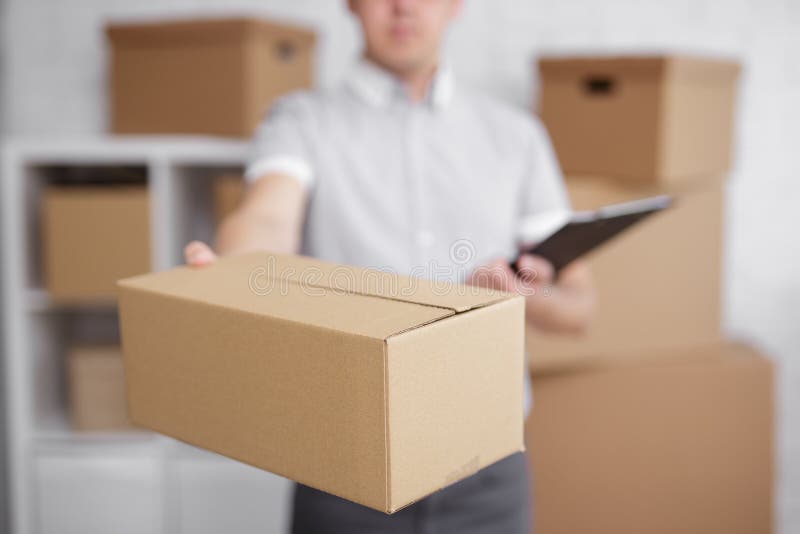 Postman with Box and Clipboard in Warehouse or Storage Stock Photo ...