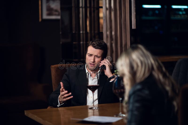 Work Call during a Date in a Restaurant, a Man Talking on the Phone ...