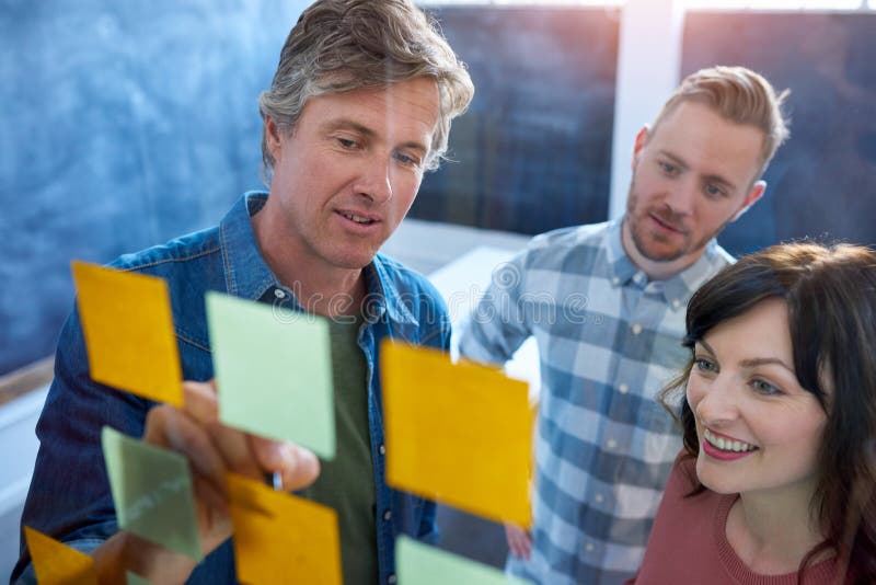Work Colleagues Brainstorming with Sticky Notes in a Modern Office ...