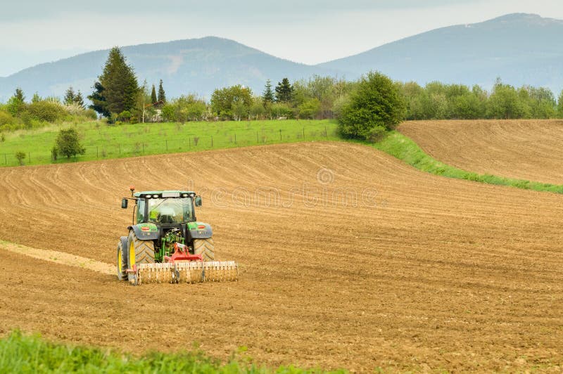 Work in the Field, the Farmer in the Tractor Plows the Field, in the ...
