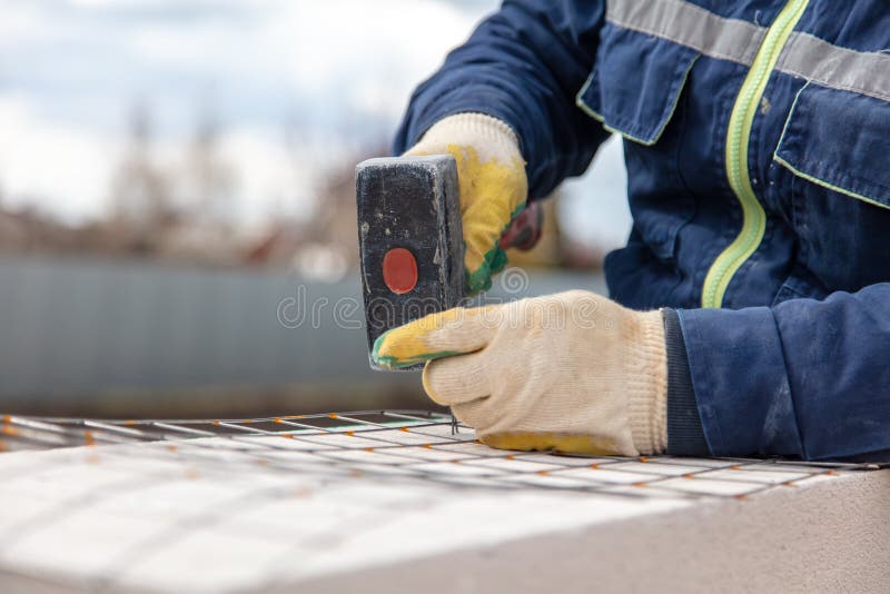 Work Hammer Hammers a Metal Mesh between the Bricks in the Wall Stock ...