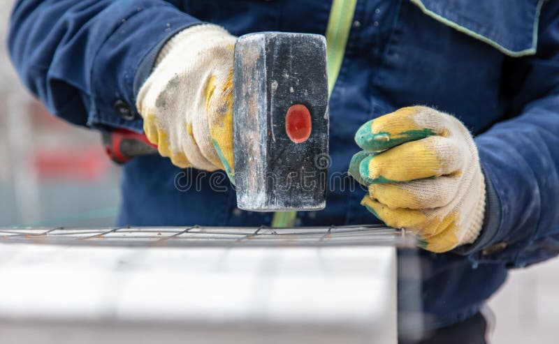 Work Hammer Hammers a Metal Mesh between the Bricks in the Wall Stock ...