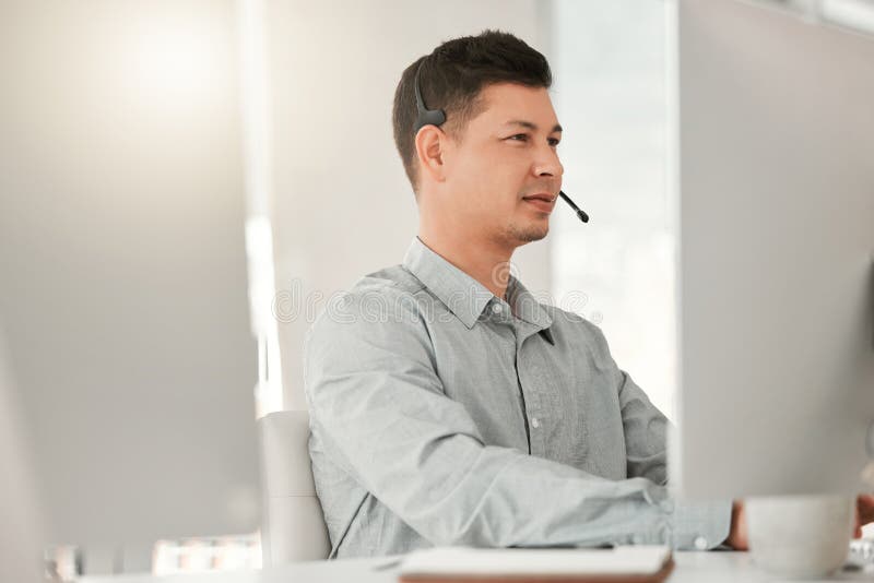 Work Keeps Him Busy All Day. a Young Male Call Center Agent Using a ...