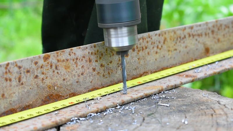 A Builder Drills Holes in a Rusty Metal Beam. Engineer Makes Holes in ...