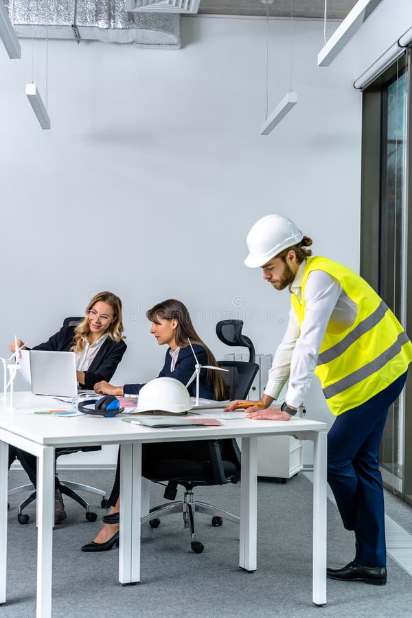Male Engineer in a Yellow Vest and Card Cap Working in the Office Stock ...