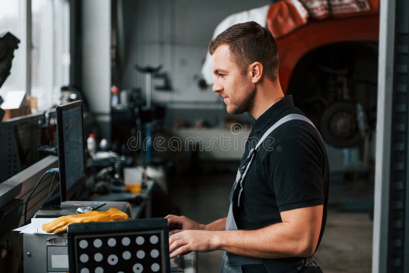 Work in Progress. Man in Uniform is in the Auto Service Stock Photo ...