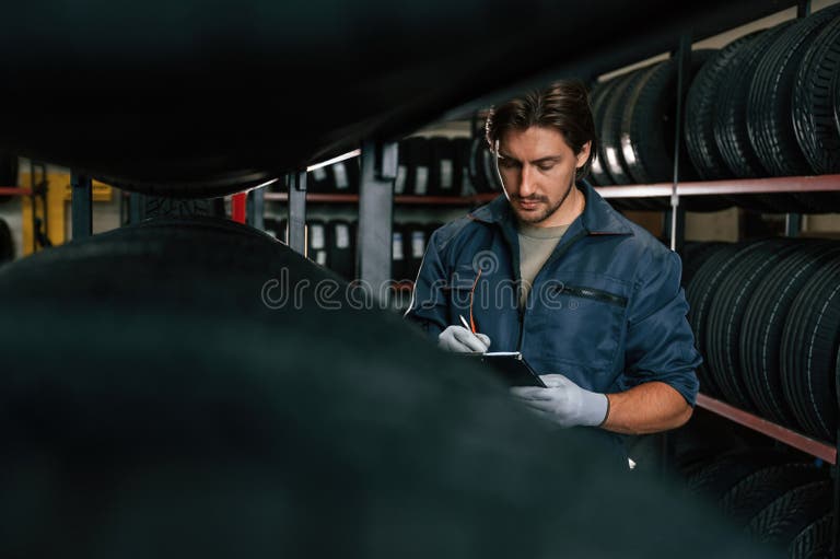 Work in Progress, Manager is in Warehouse. Man is in the Tire Fitting ...