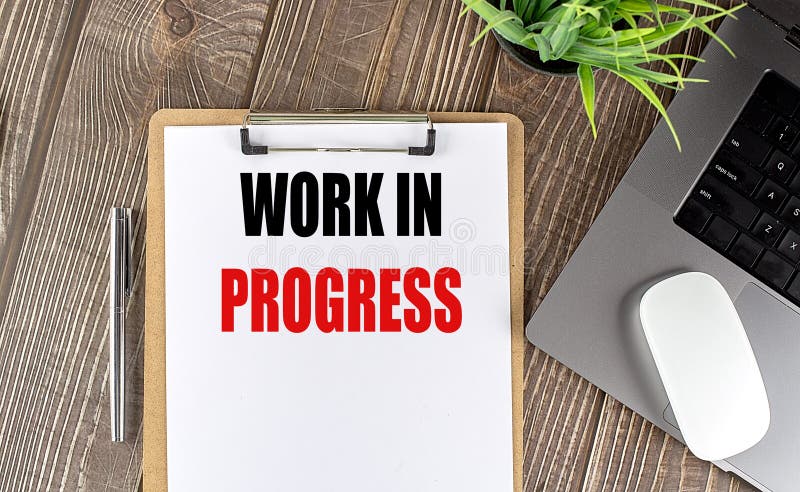 WORK in PROGRESS Text on Clipboard Paper with Laptop, Mouse and Pen ...