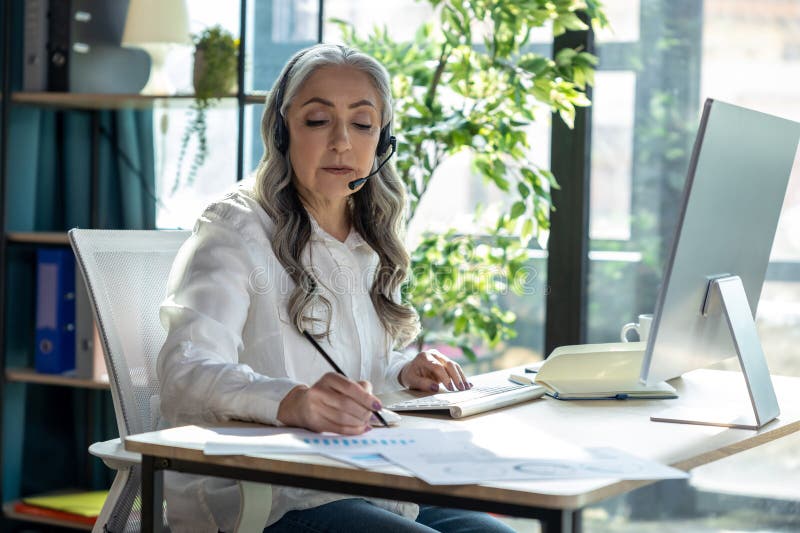 Good-looking Mature Business Woman at the Computrer Looking Busy Stock ...