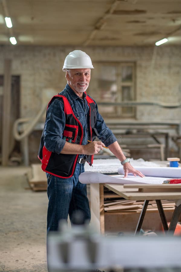 Man in Protective Helmet Working in a Workshop with Drawings Stock ...
